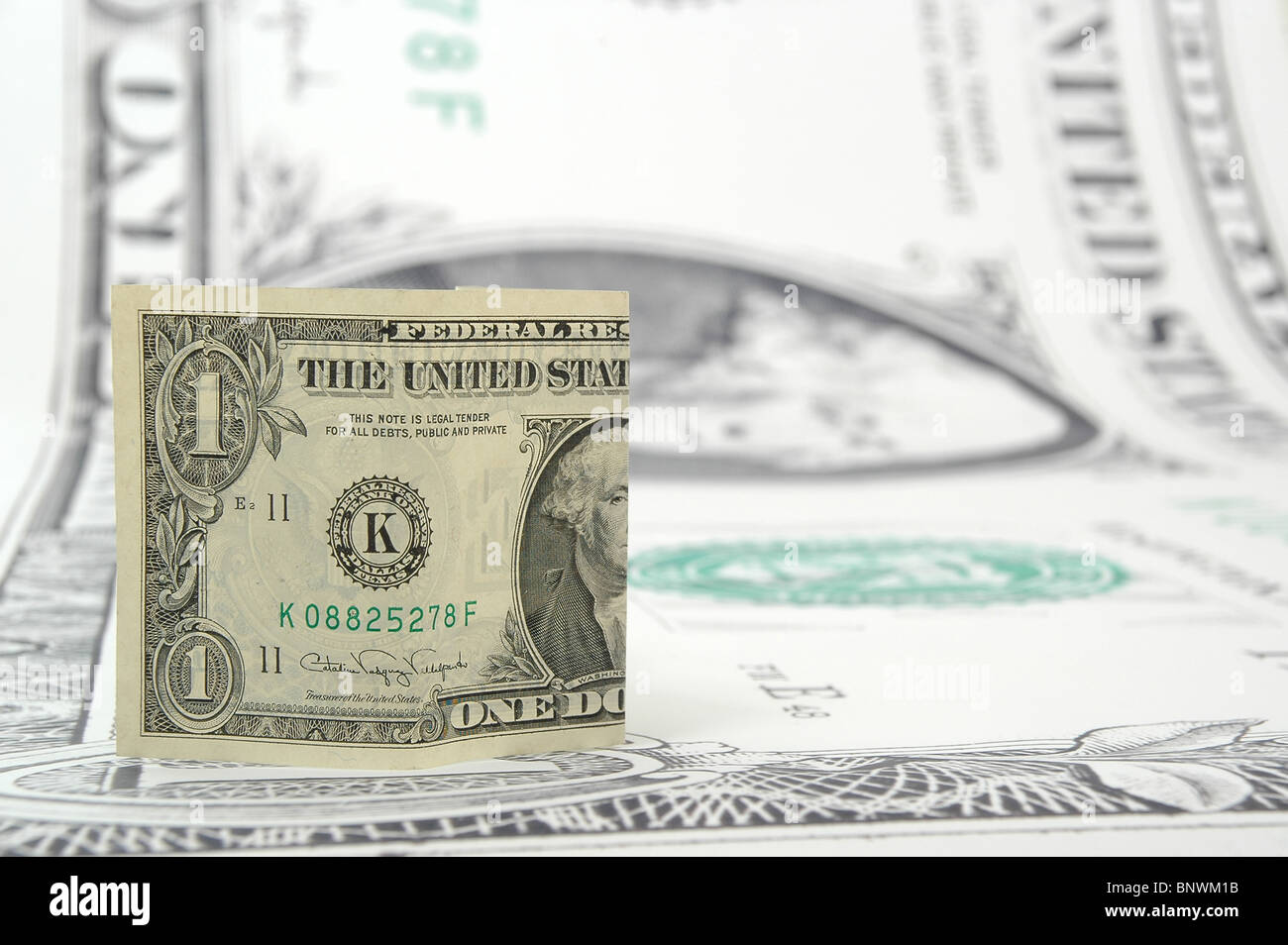 One American dollar bill on top of a big 100 dollar bill. Isolated on a ...