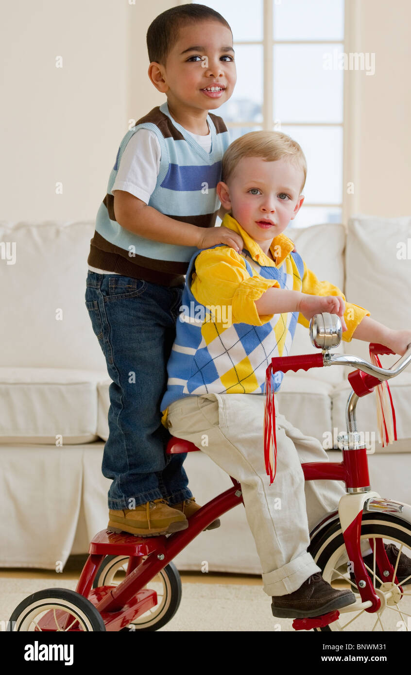 Two children on a tricycle Stock Photo - Alamy
