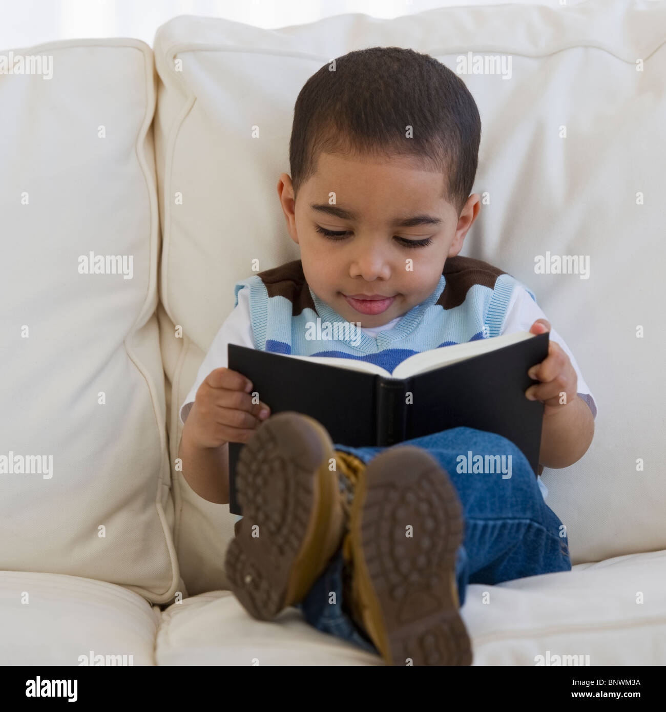 Young child looking at a book Stock Photo - Alamy