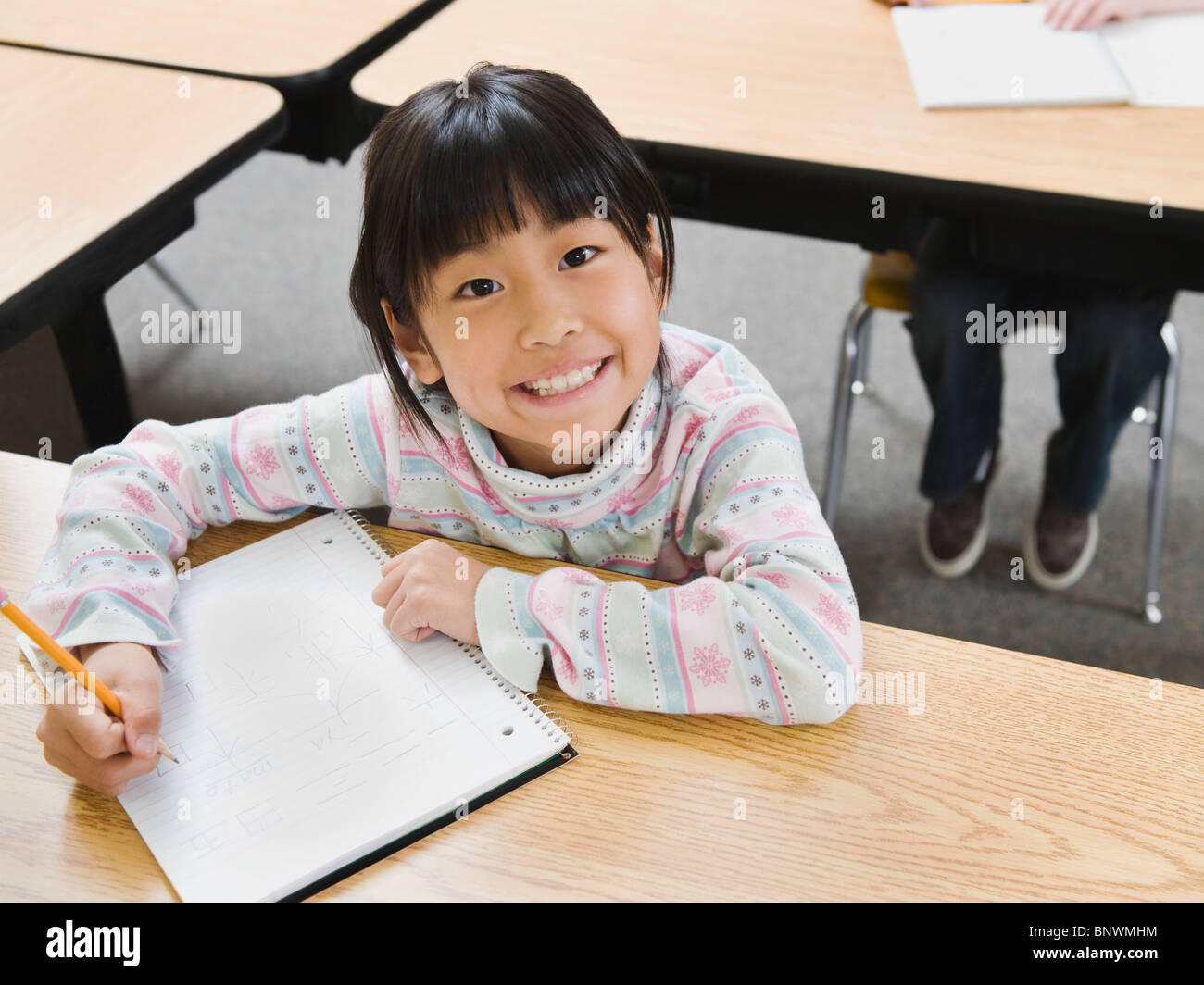 Elementary student writing in her notebook Stock Photo - Alamy