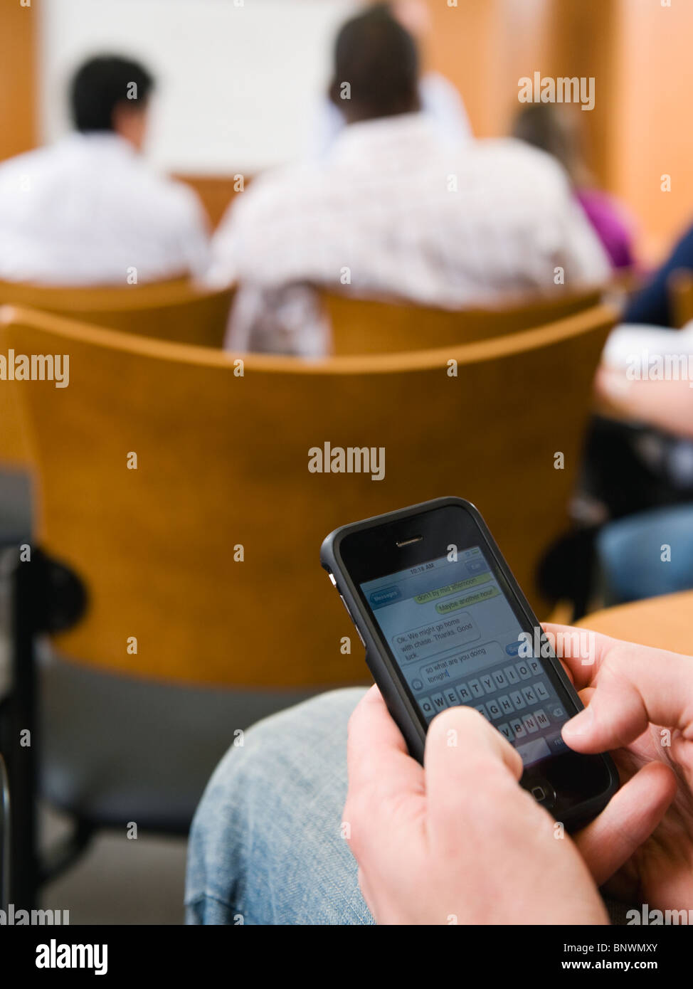 College student texting in lecture hall Stock Photo - Alamy
