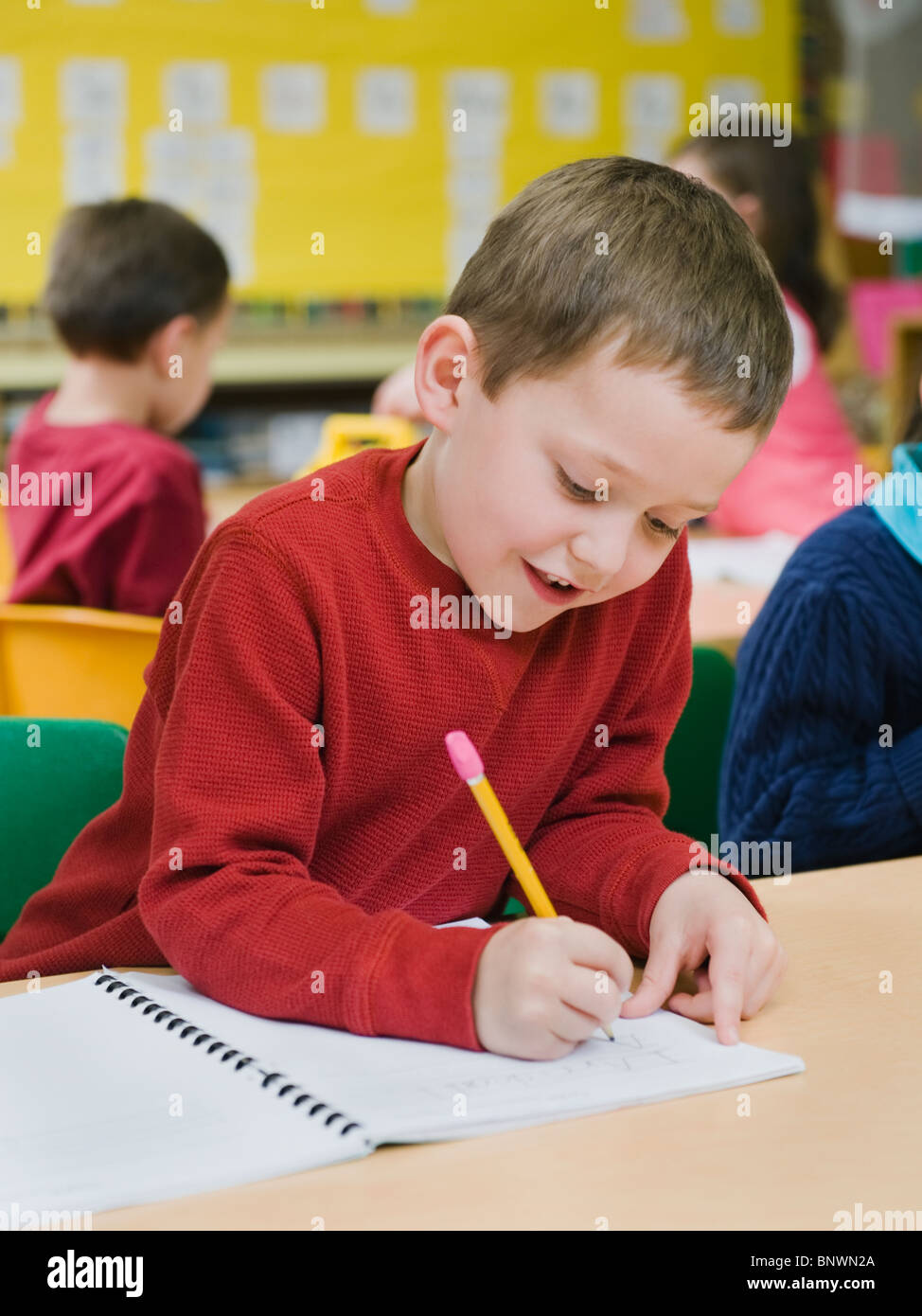 Kindergarten student writing in notebook Stock Photo - Alamy