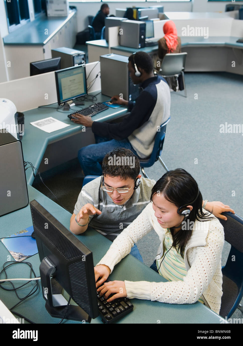 Adult students working on computers at a learning center Stock Photo ...