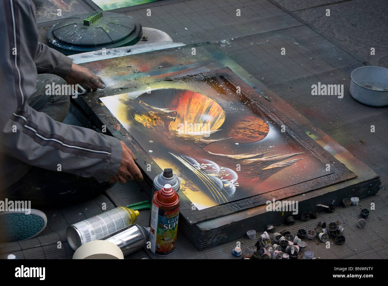 Street artist creating futuristic paintings with spray paints in the ...