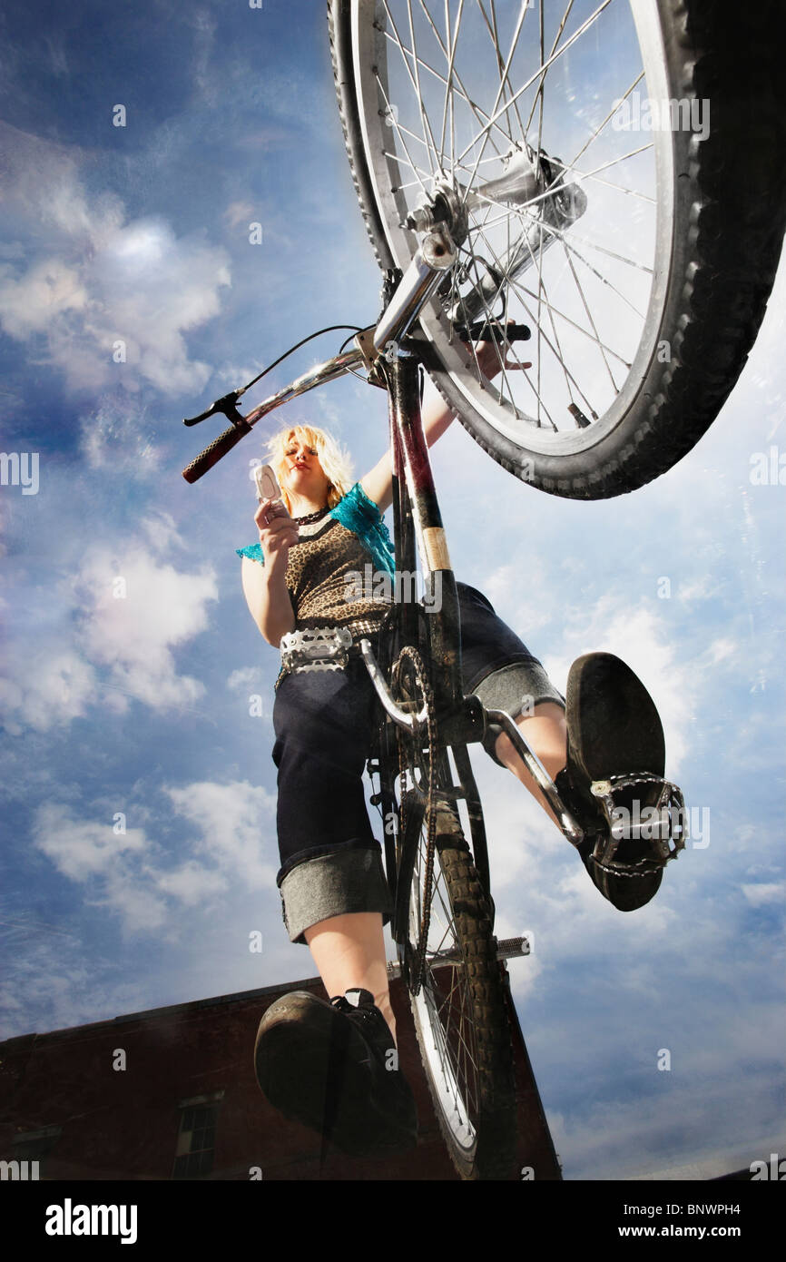 Teenage girl doing a bike trick Stock Photo - Alamy