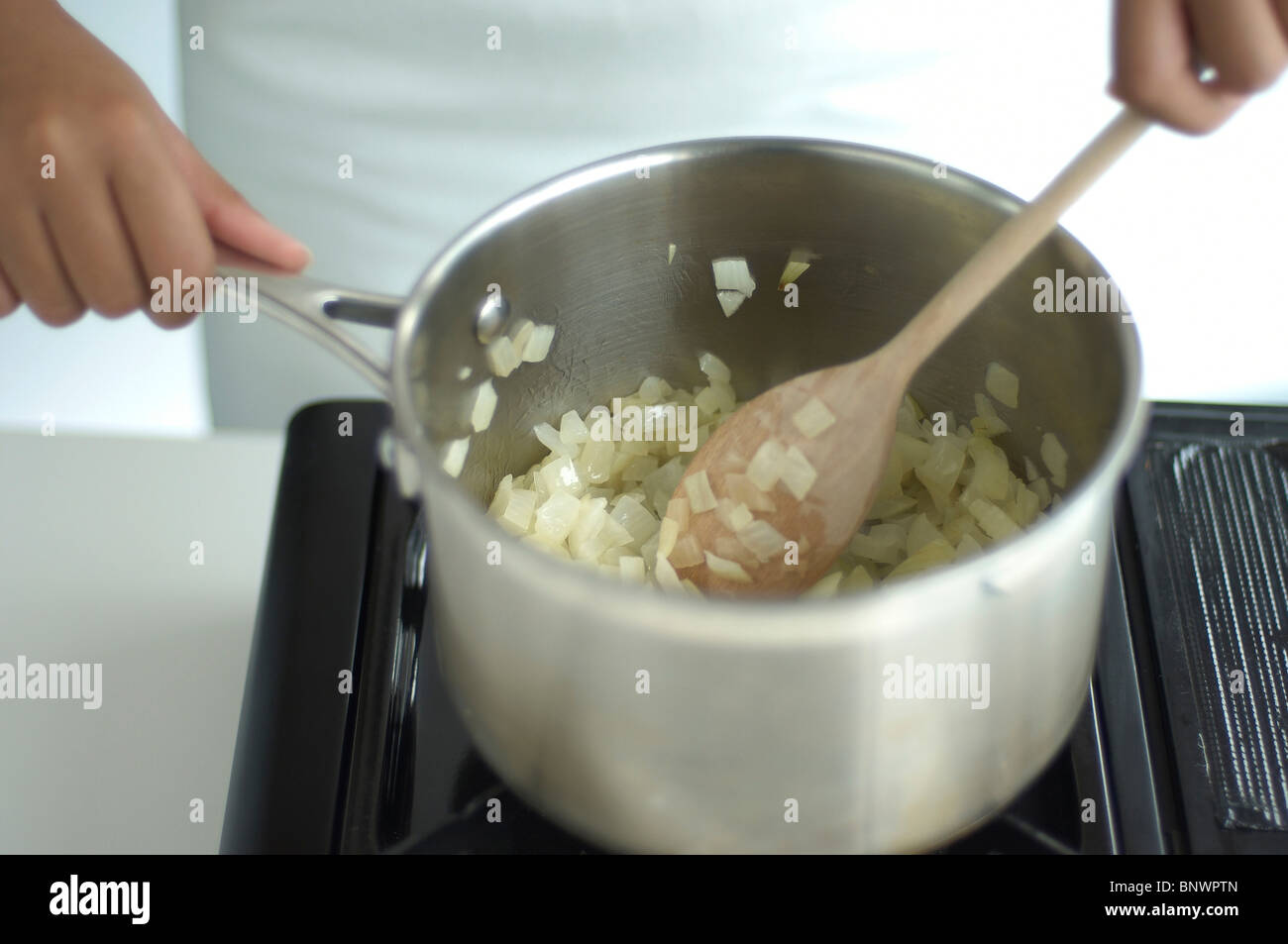 Stirring onions in a saucepan Stock Photo - Alamy