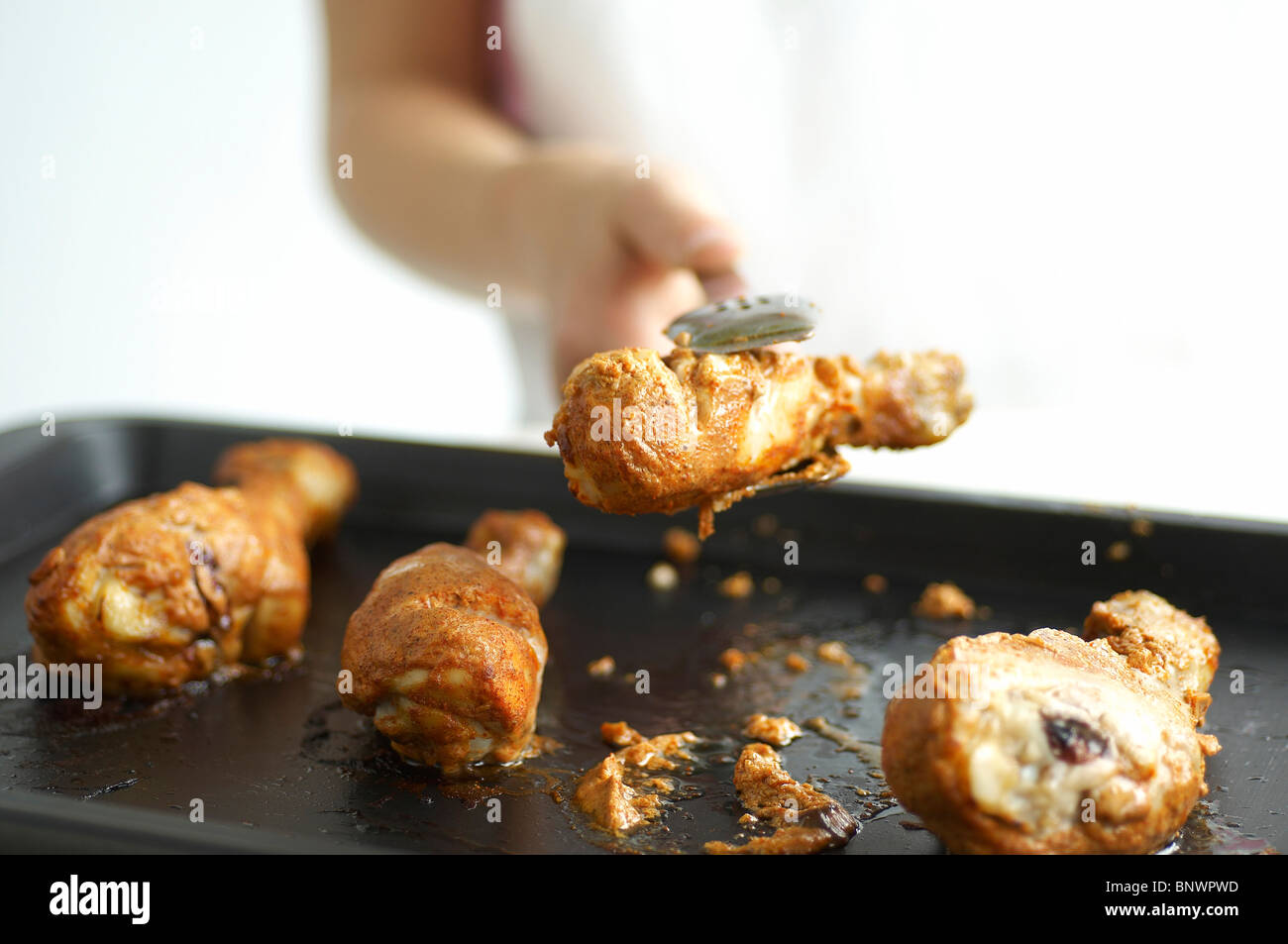 Chicken on tongs Stock Photo - Alamy