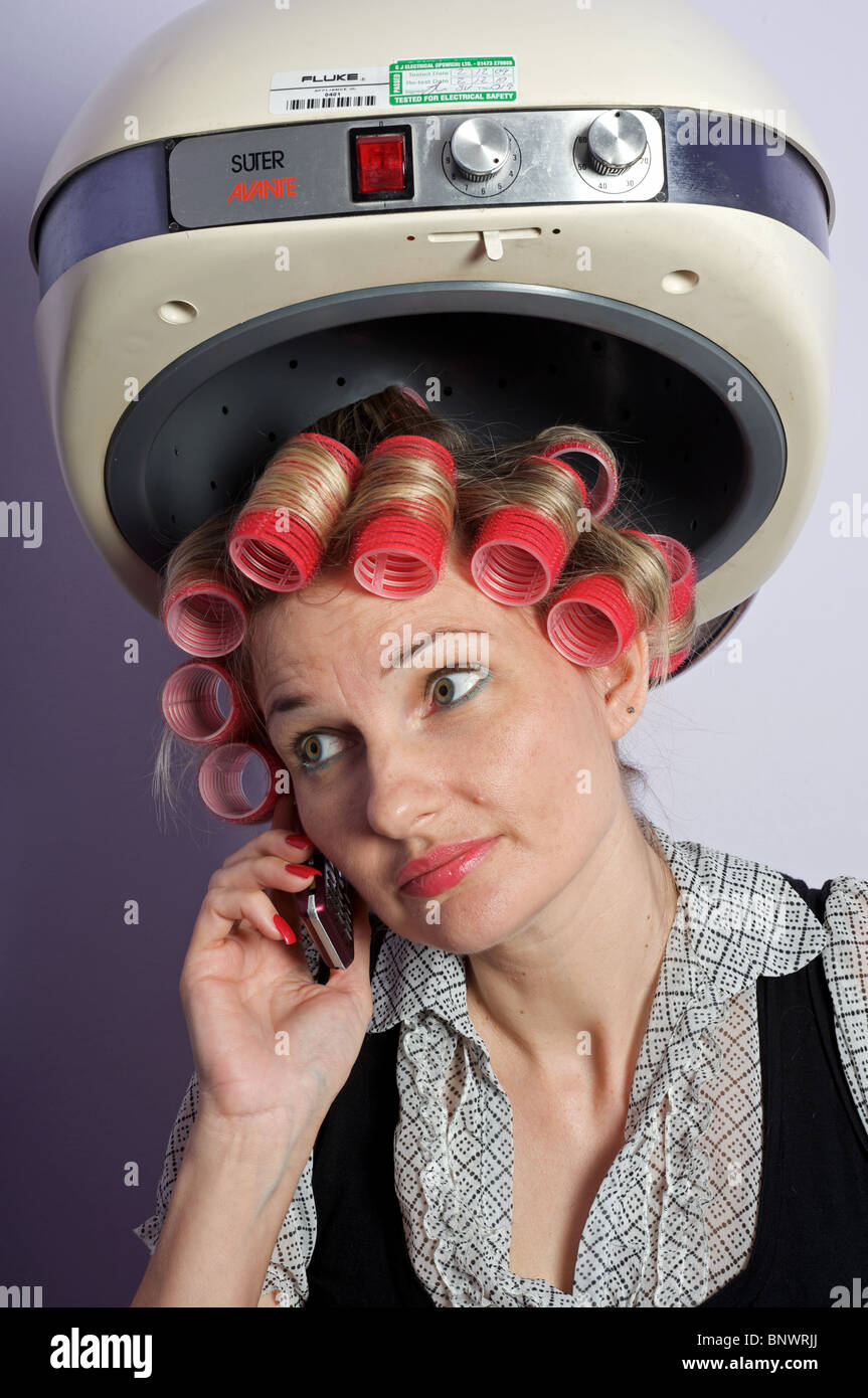Woman using a mobile phone while at the hairdressers Stock Photo - Alamy