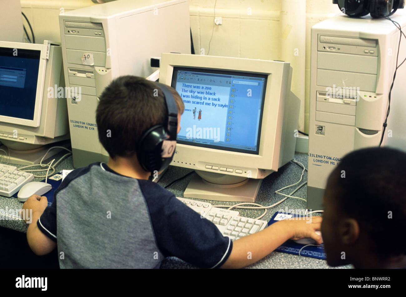 Primary school boy at the computer with headphones Stock Photo - Alamy
