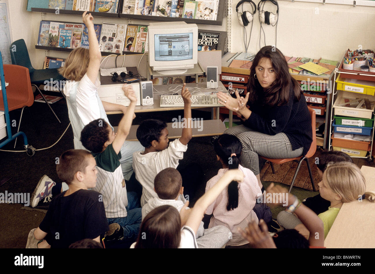 Primary school children and teacher in classroom scene Stock Photo - Alamy