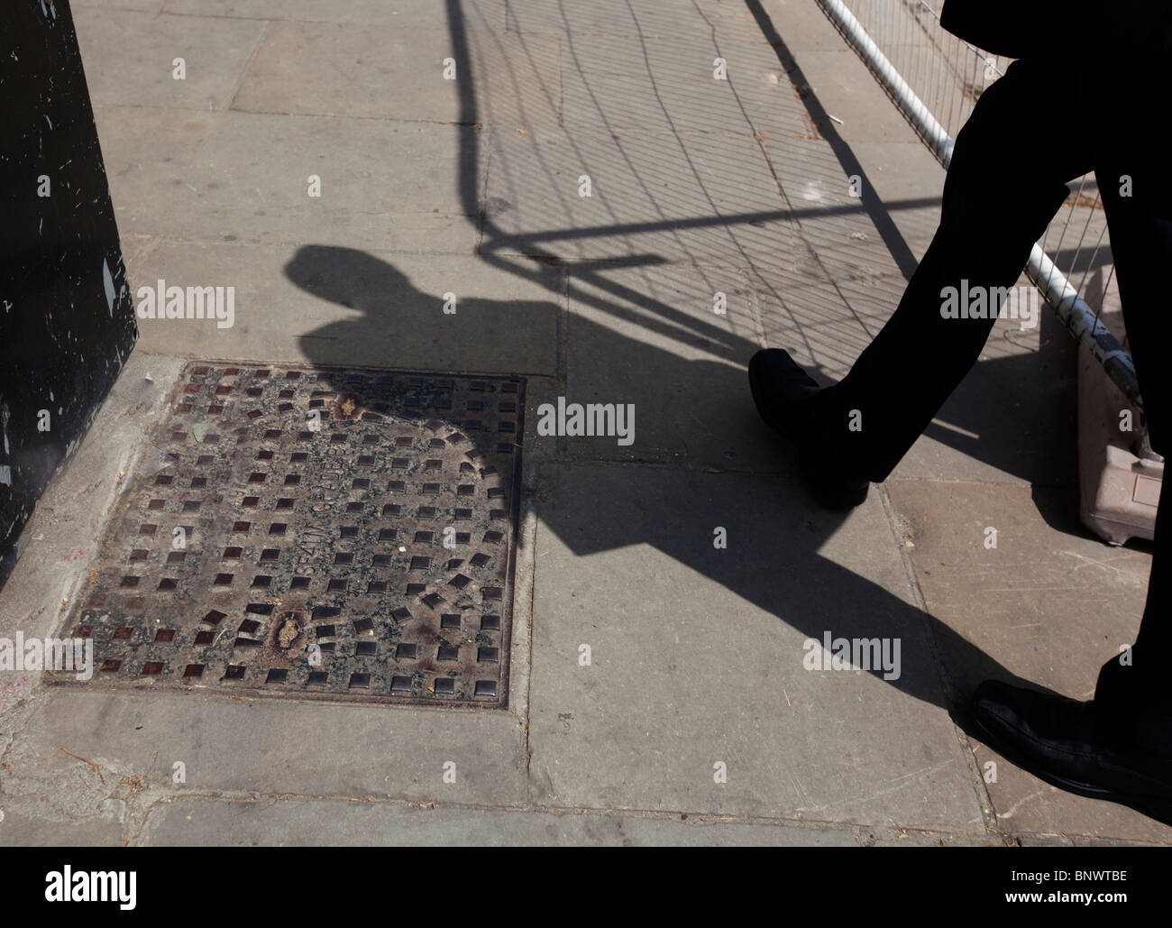 Shadow of a man walking in a city street Stock Photo - Alamy