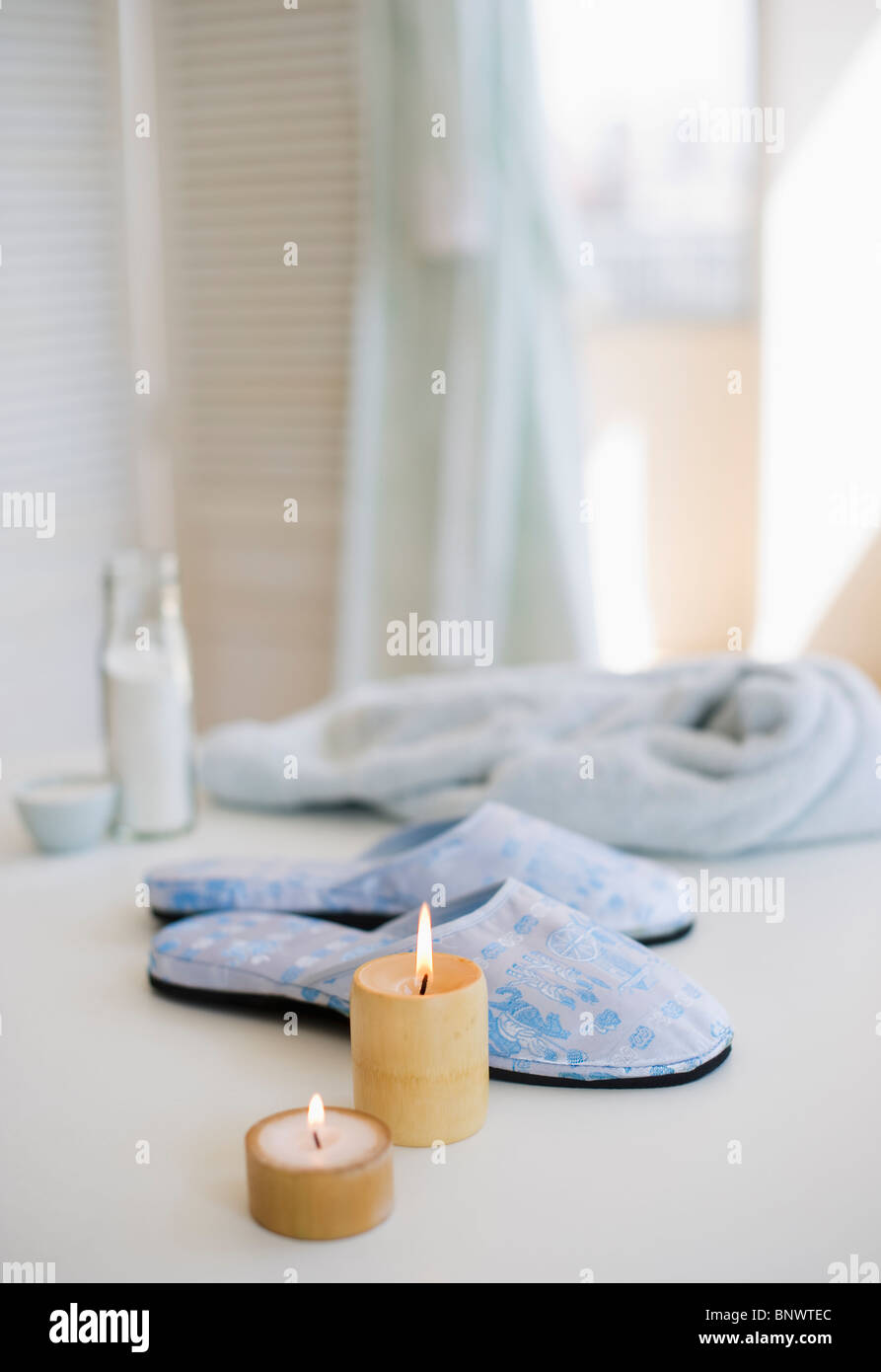 Candles slippers and robe at spa Stock Photo - Alamy