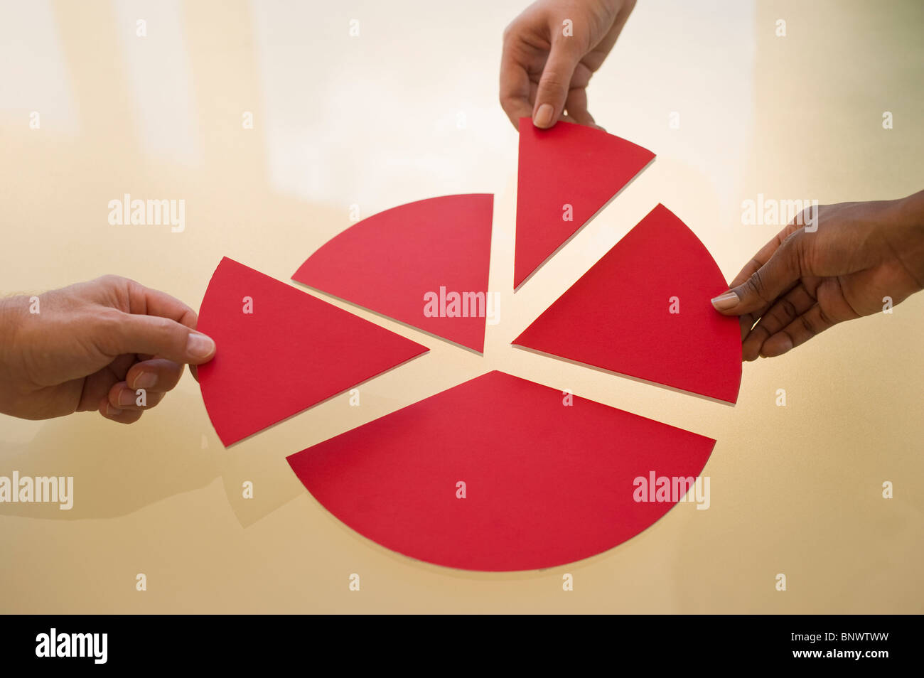 Hands dividing pieces of pie chart Stock Photo - Alamy