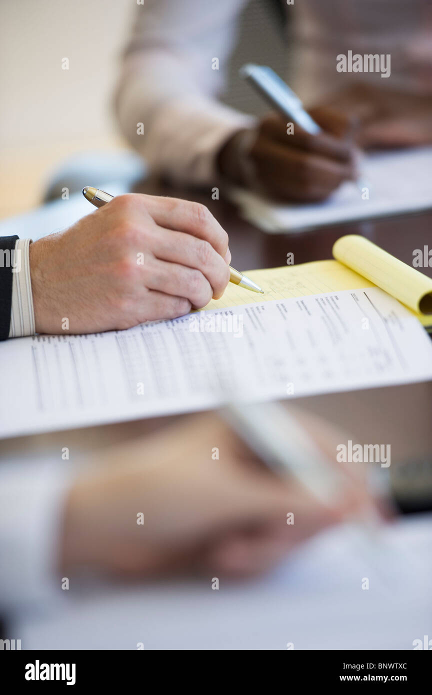 Business people writing notes during business meeting Stock Photo - Alamy