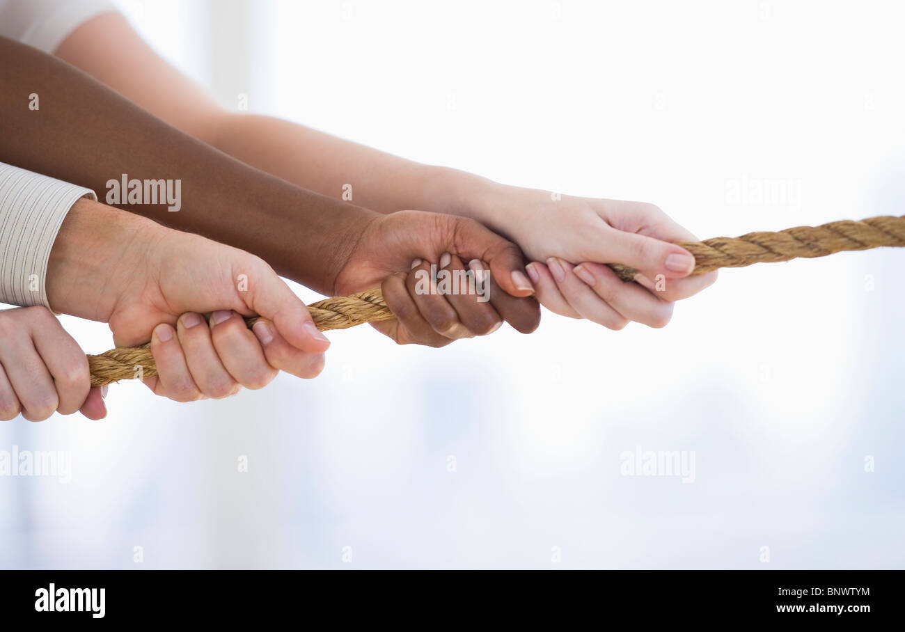 Hands pulling rope Stock Photo - Alamy