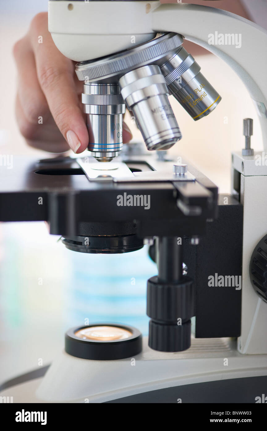Hands on a microscope Stock Photo - Alamy