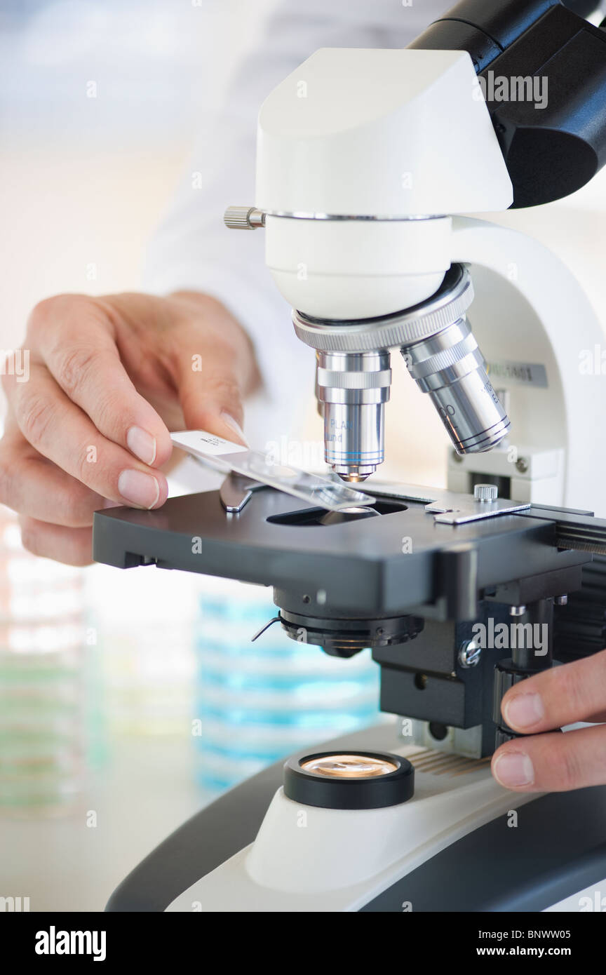 Hands on a microscope Stock Photo - Alamy