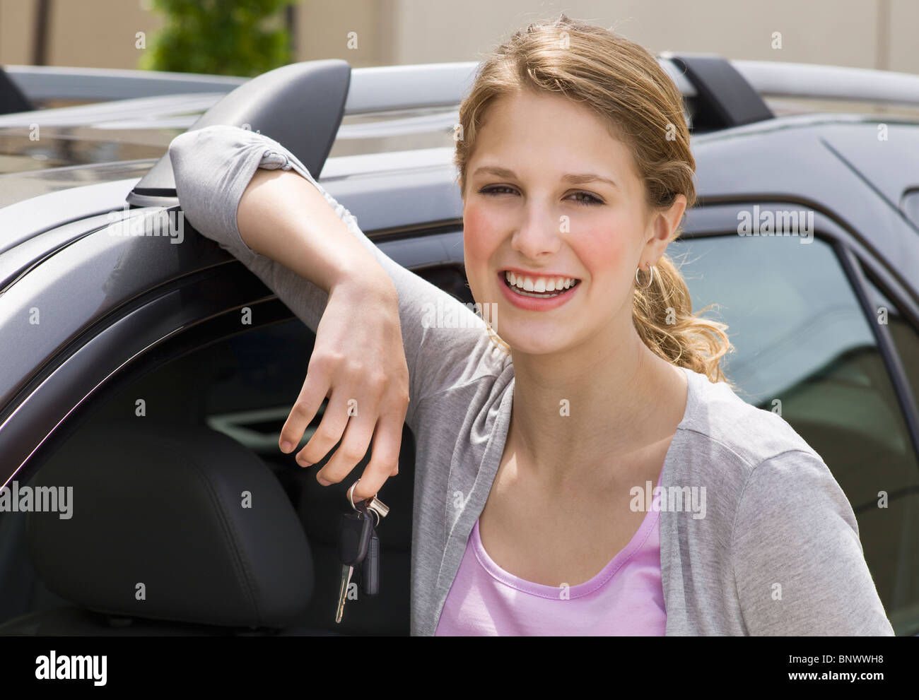 Woman leaning against her new car Stock Photo - Alamy