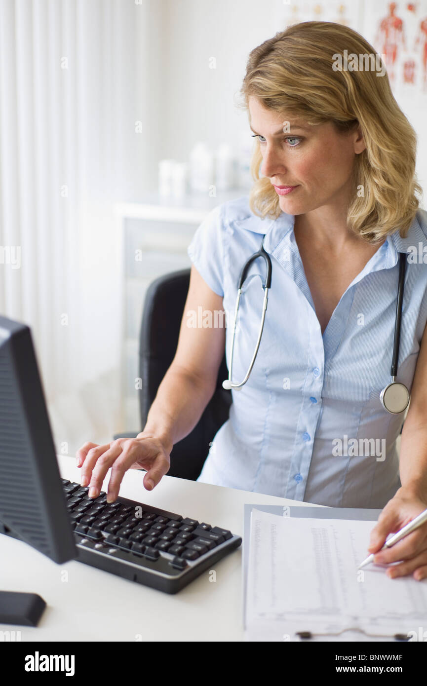 Female doctor working at her desk Stock Photo - Alamy