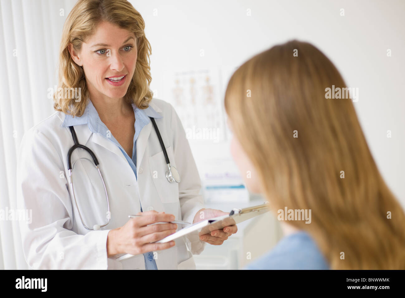 Doctor talking to patient in exam room Stock Photo - Alamy