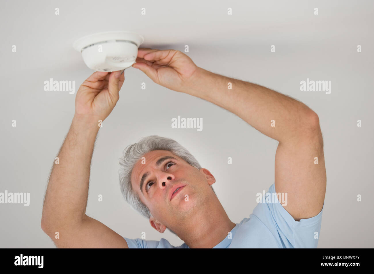 Man testing smoke detector Stock Photo - Alamy