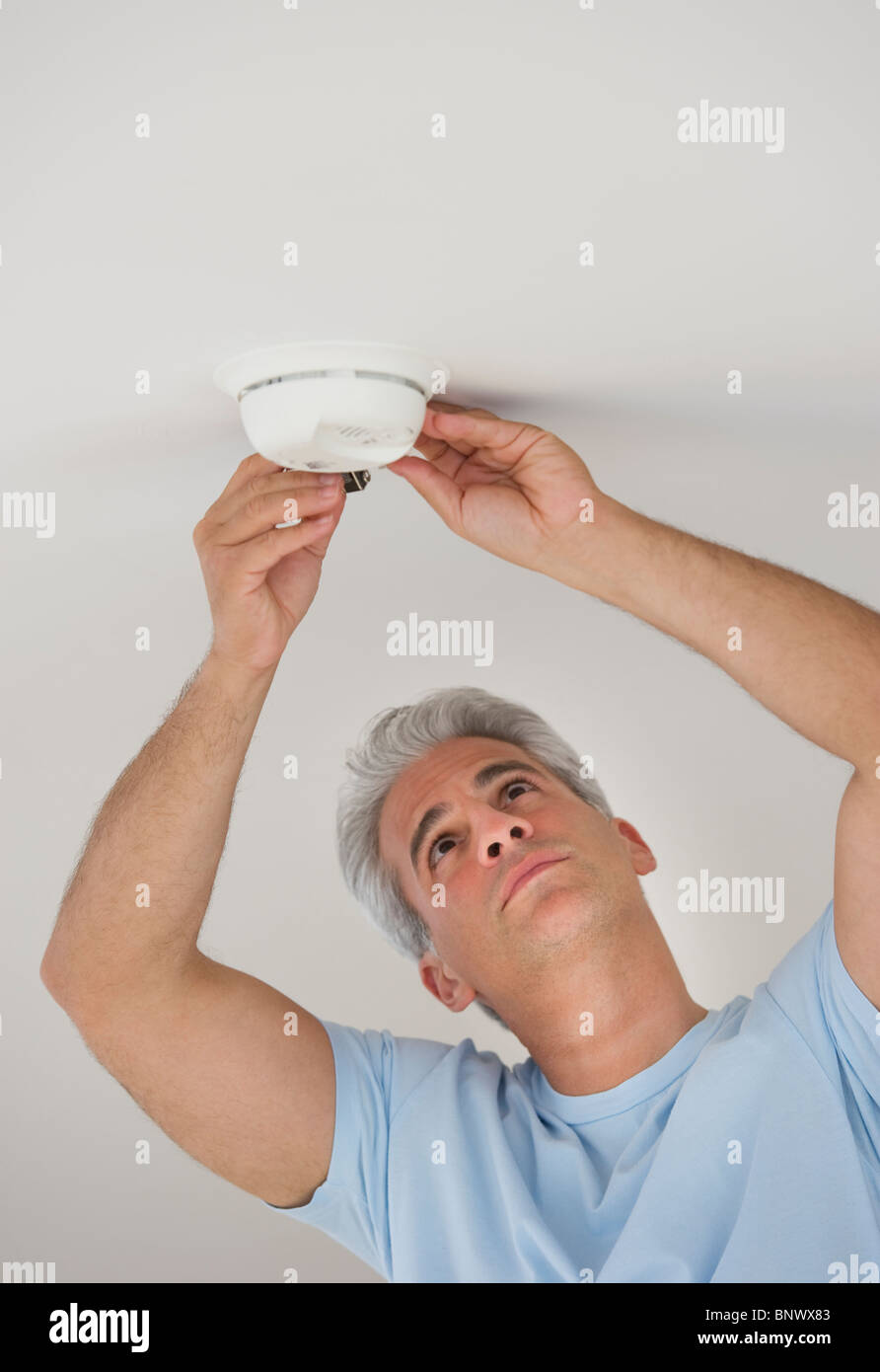 Man changing battery in smoke detector Stock Photo - Alamy