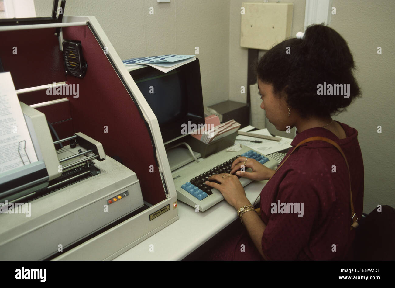 Office worker in the eighties with old fashioned computer and printer ...
