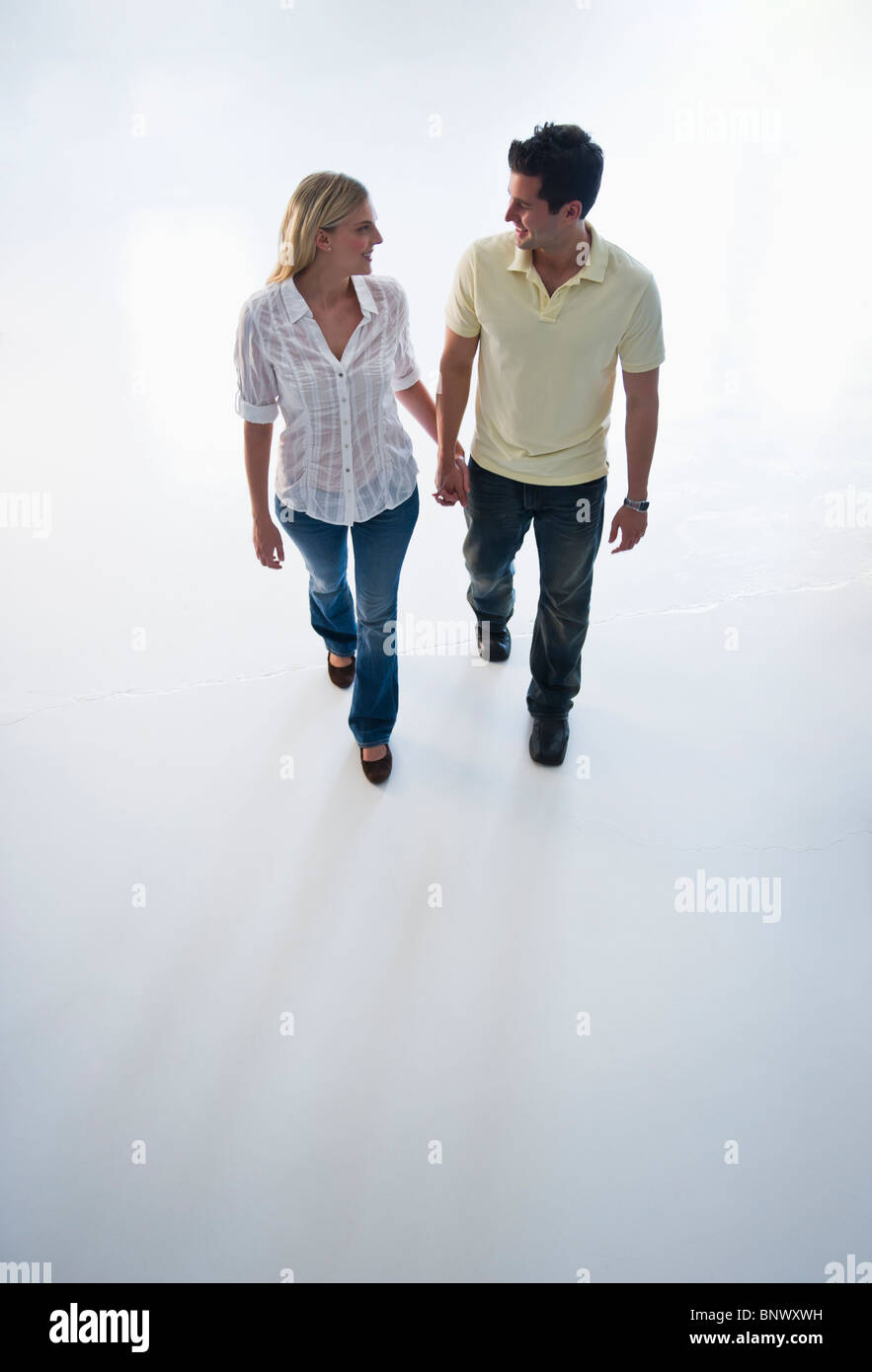 Happy couple walking hand in hand Stock Photo - Alamy