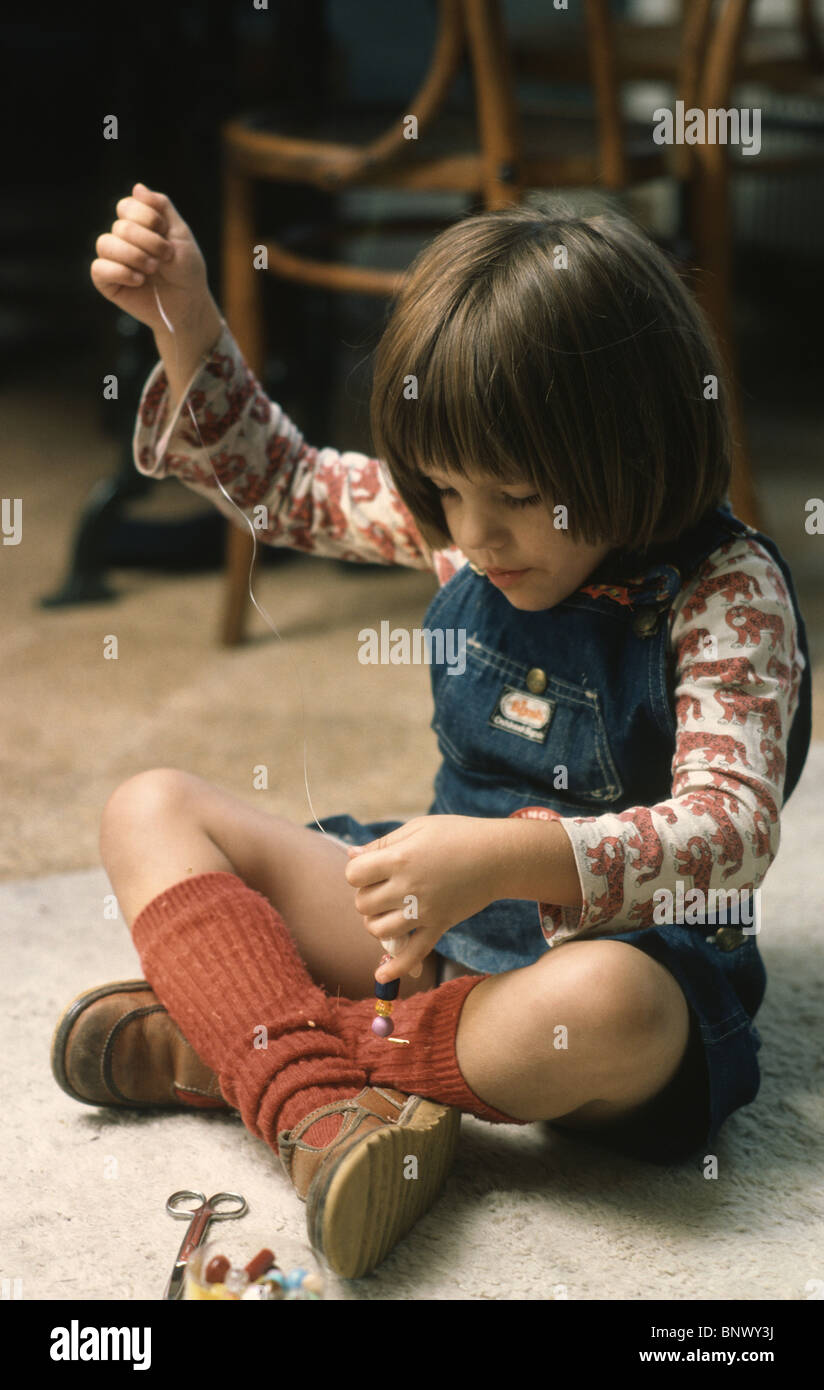young girl threading beads Stock Photo - Alamy