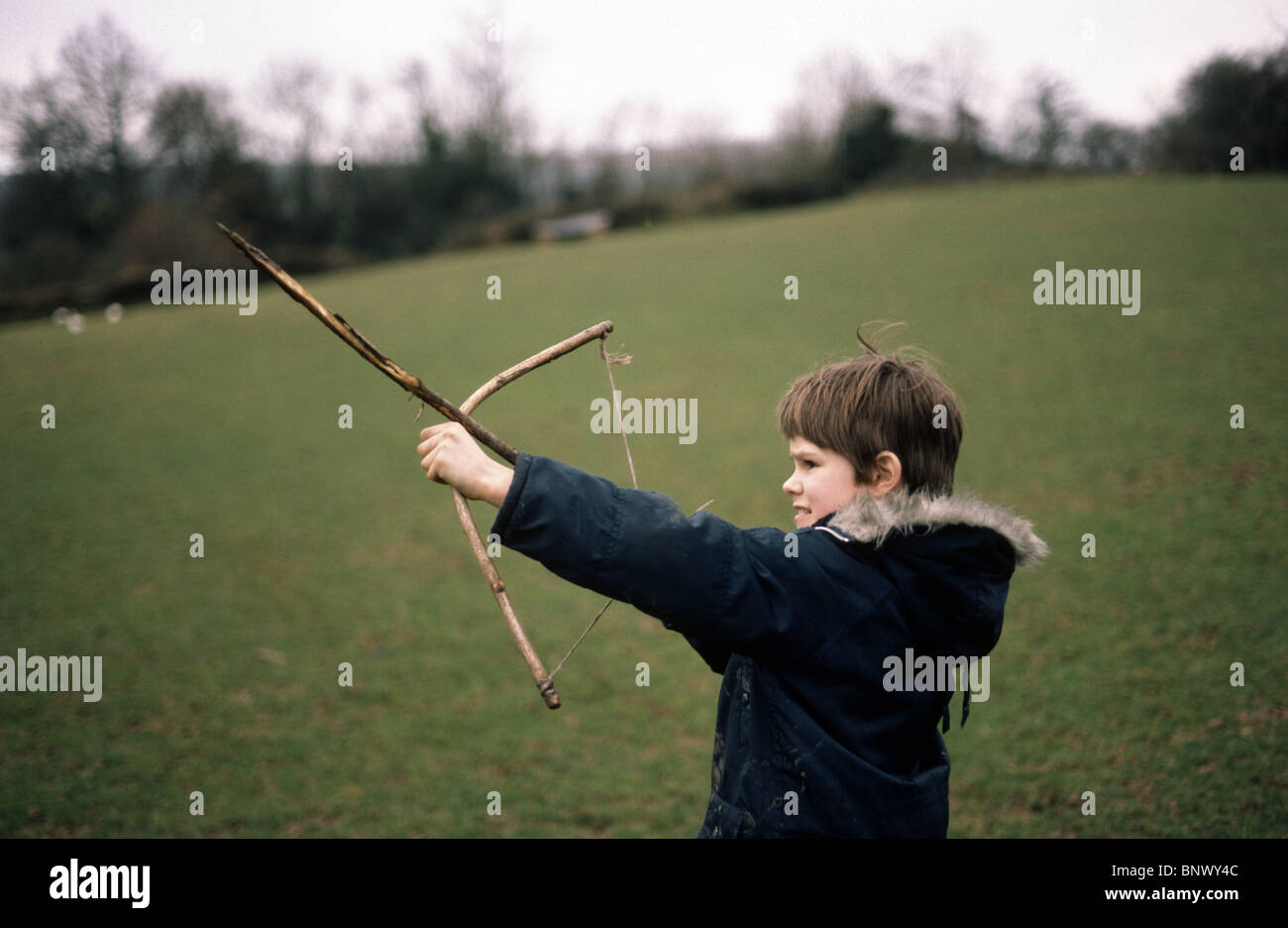 young boy playing with a bow and arrow Stock Photo - Alamy