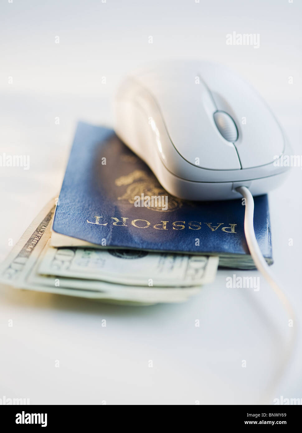 Computer mouse on top of passport and money Stock Photo - Alamy