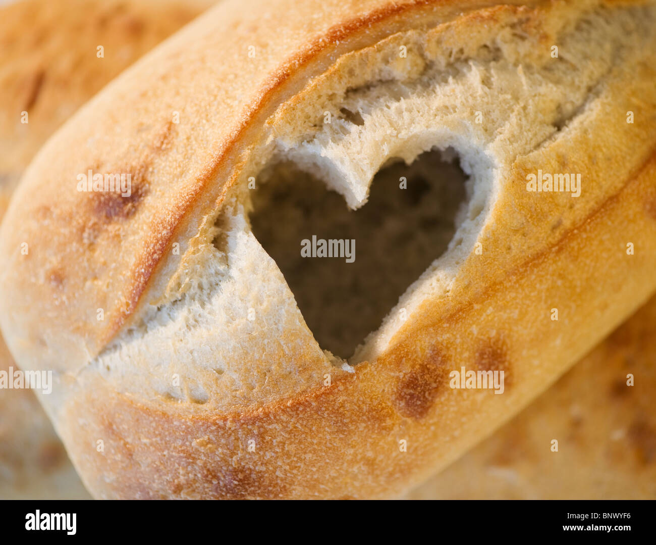 Heart cutout in loaf of bread Stock Photo - Alamy