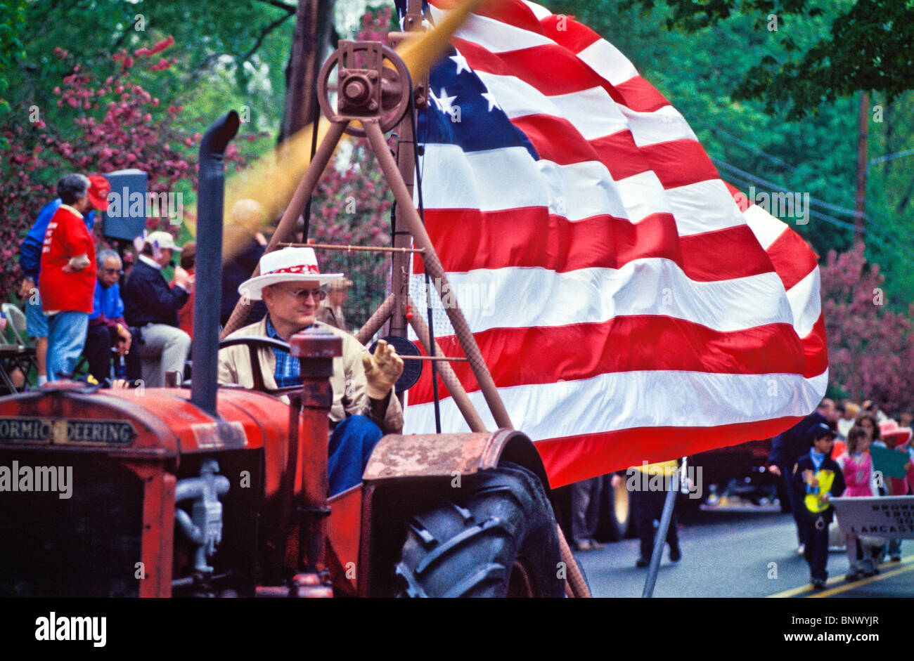 Large American flag pulled by tractor in small town parade Stock Photo ...