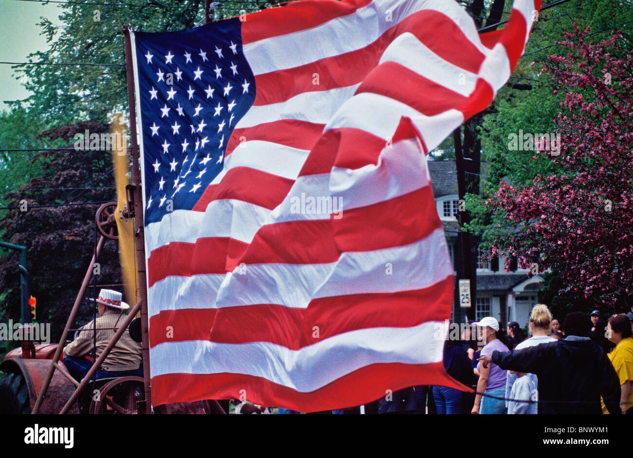 Large American flag pulled by tractor in small town parade Stock Photo ...