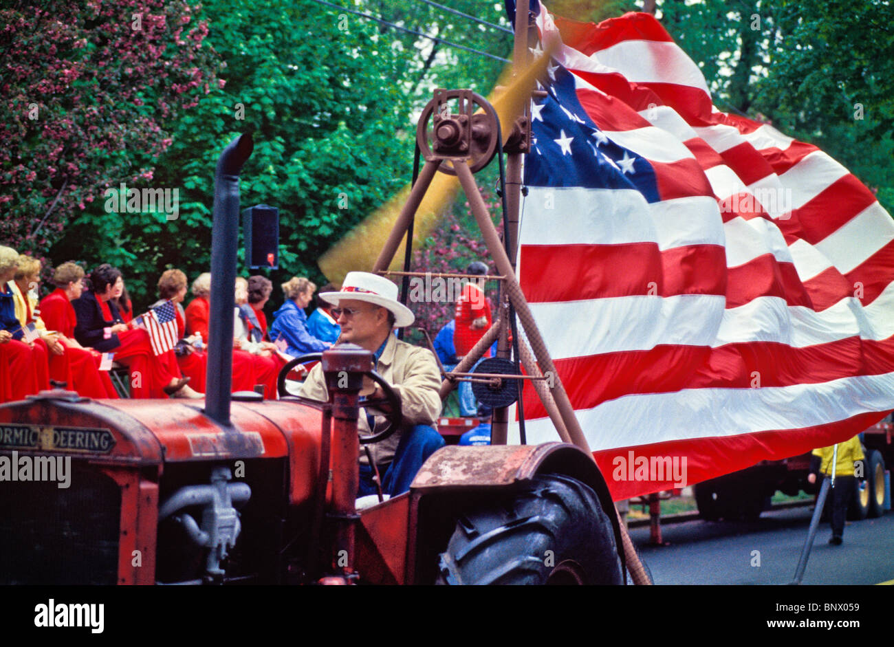 Large American flag pulled by tractor in small town parade Stock Photo ...