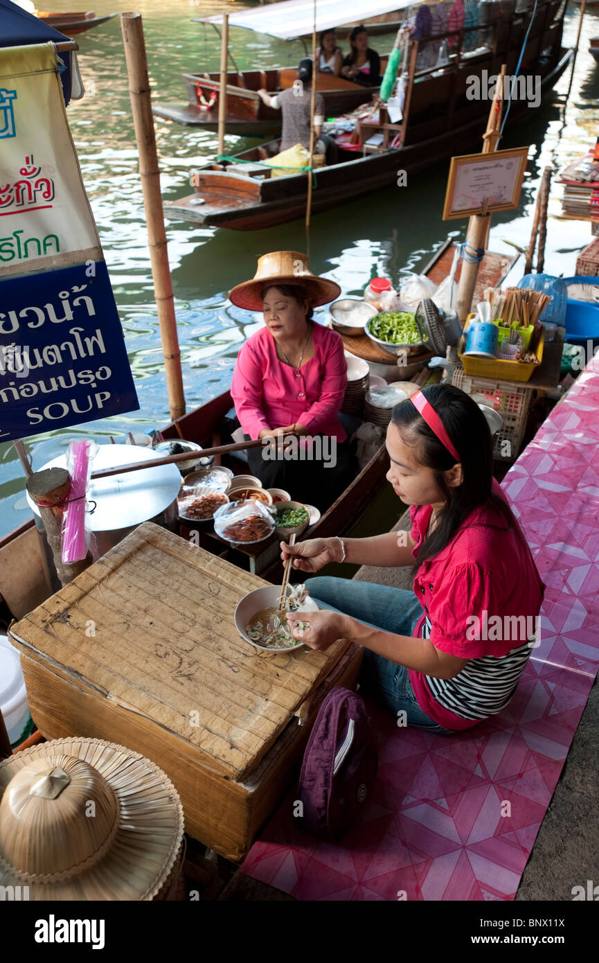 Thai girl eating breakfast at the Damnoen Saduak Floating Market ...