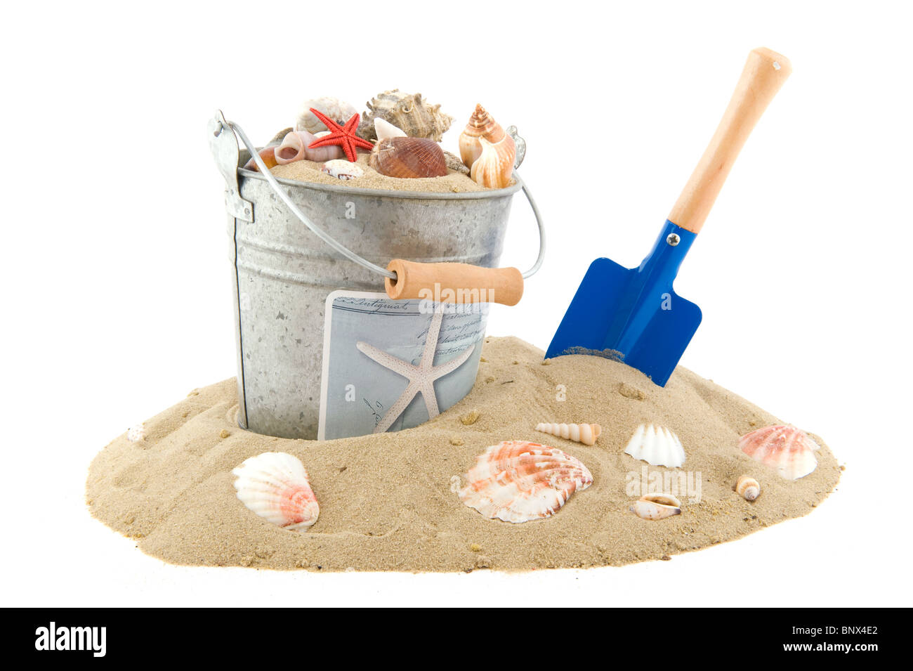 Beach bucket with shells sand and shovel Stock Photo - Alamy
