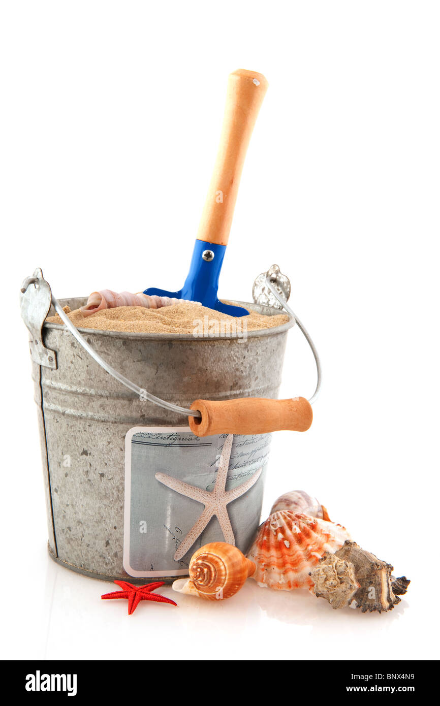 Zinc beach bucket with shells and shovel on white Stock Photo - Alamy