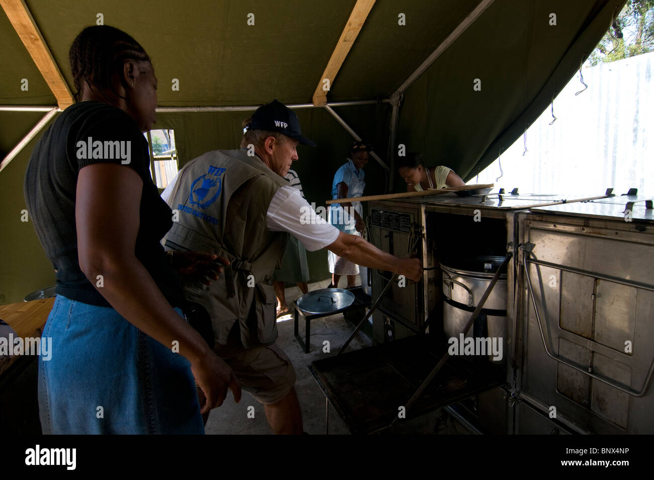 A WFP staff member supervise local people cooking in a kitchen set up ...