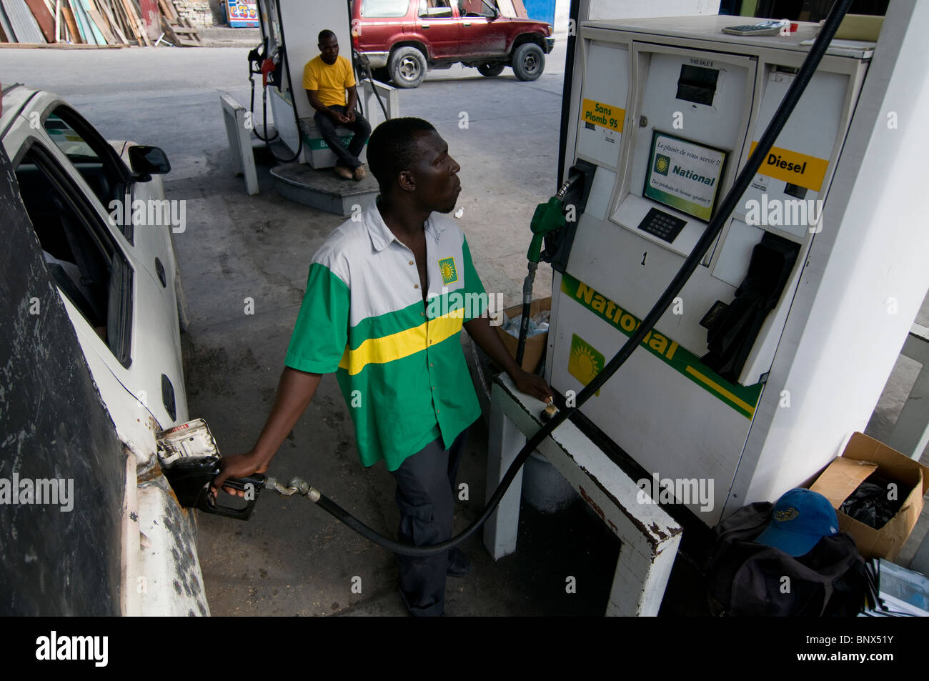 A worker fills a motor car with fuel at a National (Dinasa S.A.) petrol ...