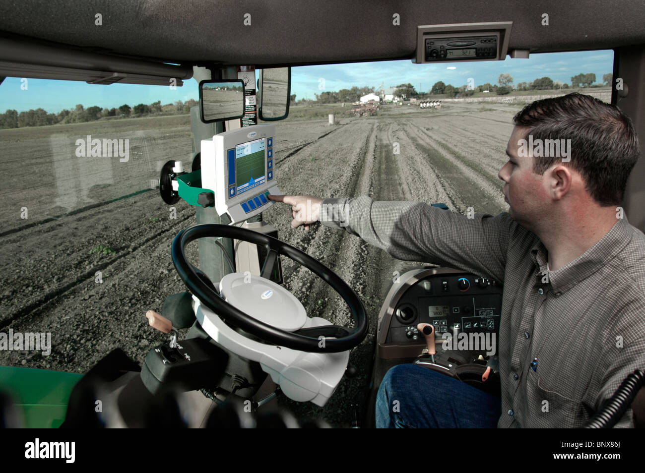 A tractor driver with GPS navigation for accurate field grading Stock ...