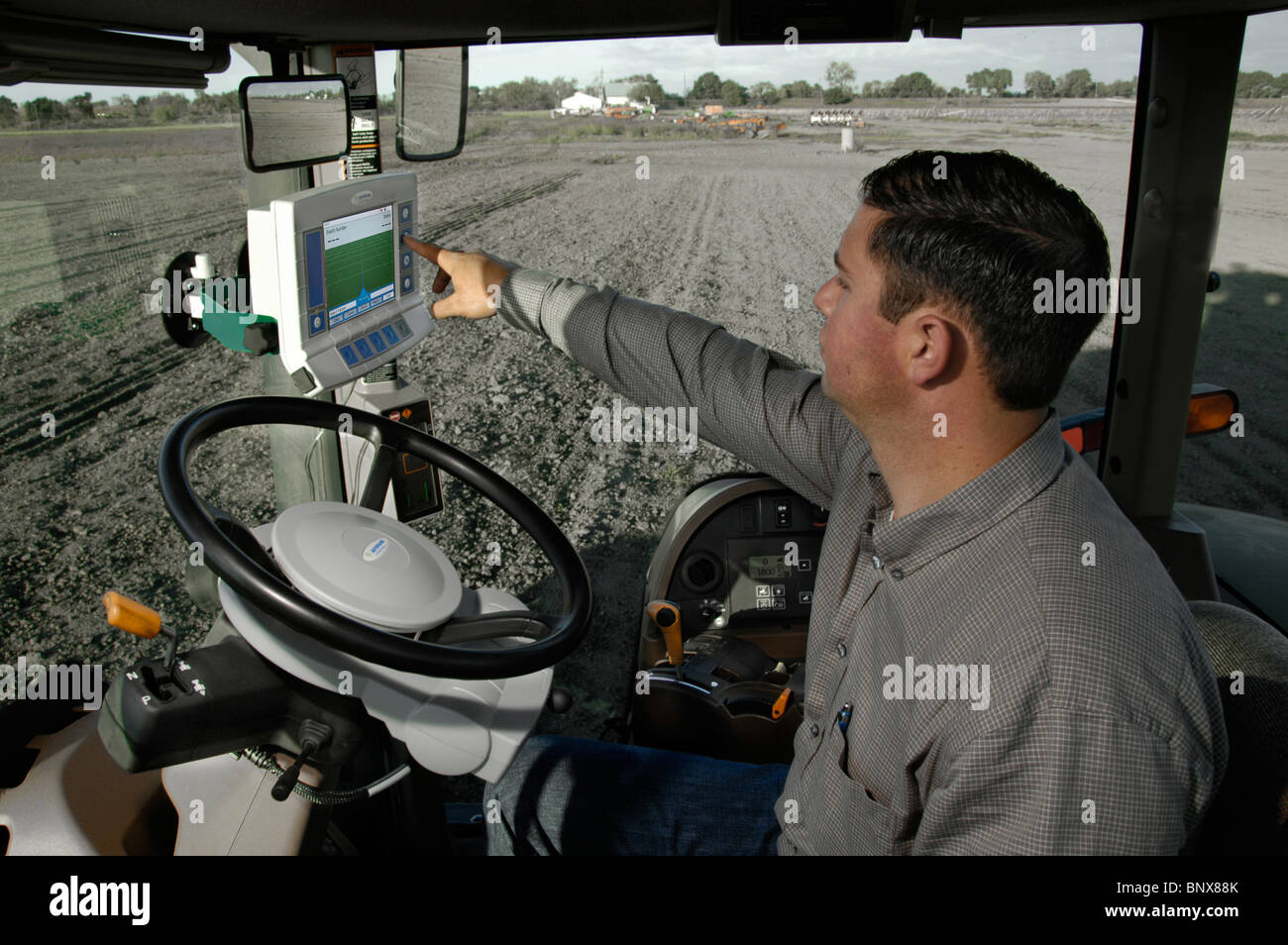 A tractor driver with GPS navigation for accurate field grading Stock ...