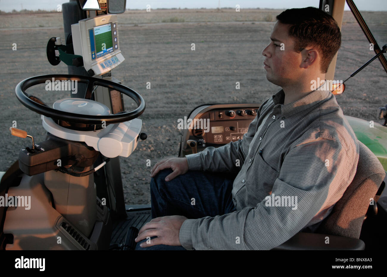 A tractor driver with GPS navigation for accurate field grading Stock ...