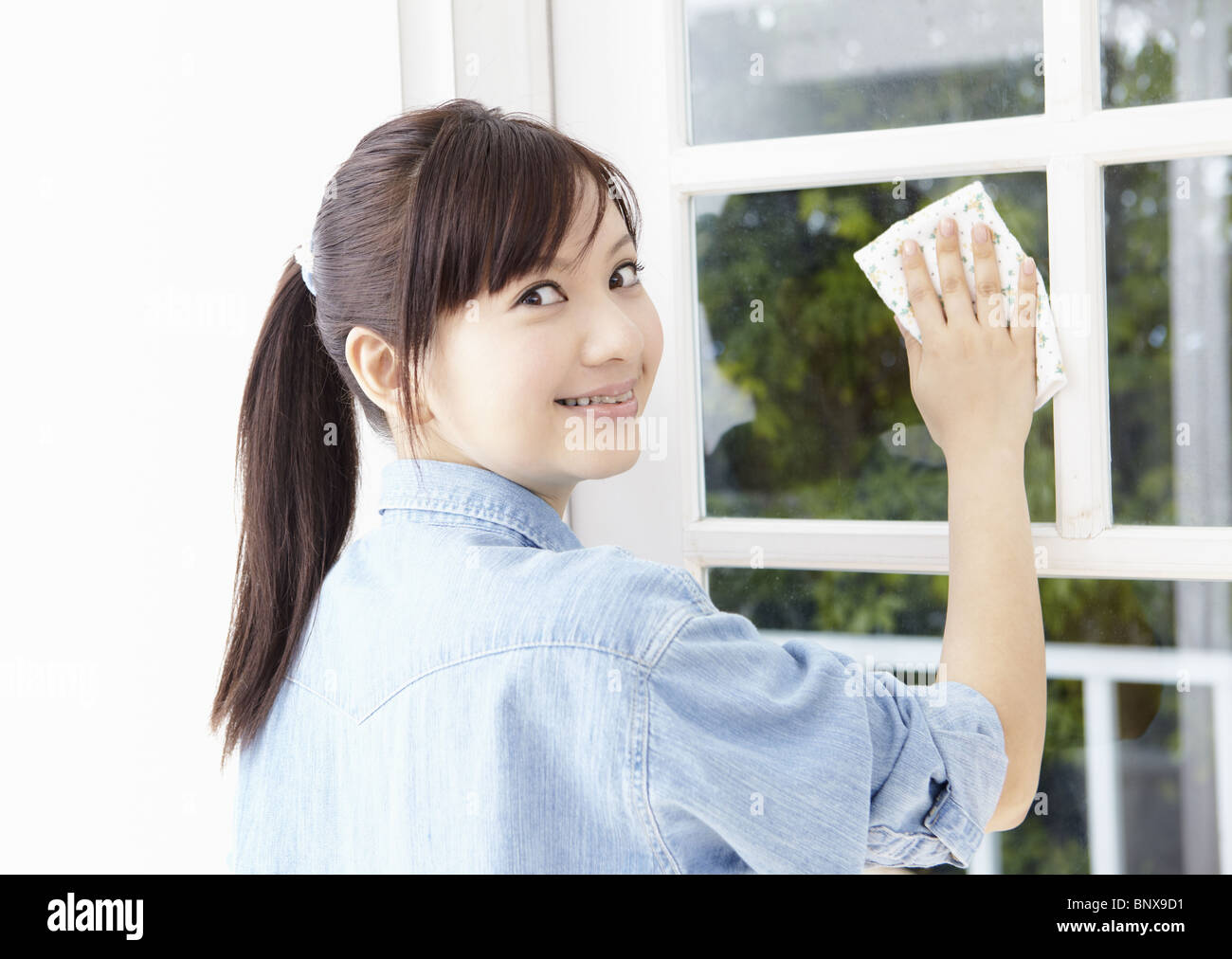 Young woman wiping the window Stock Photo - Alamy