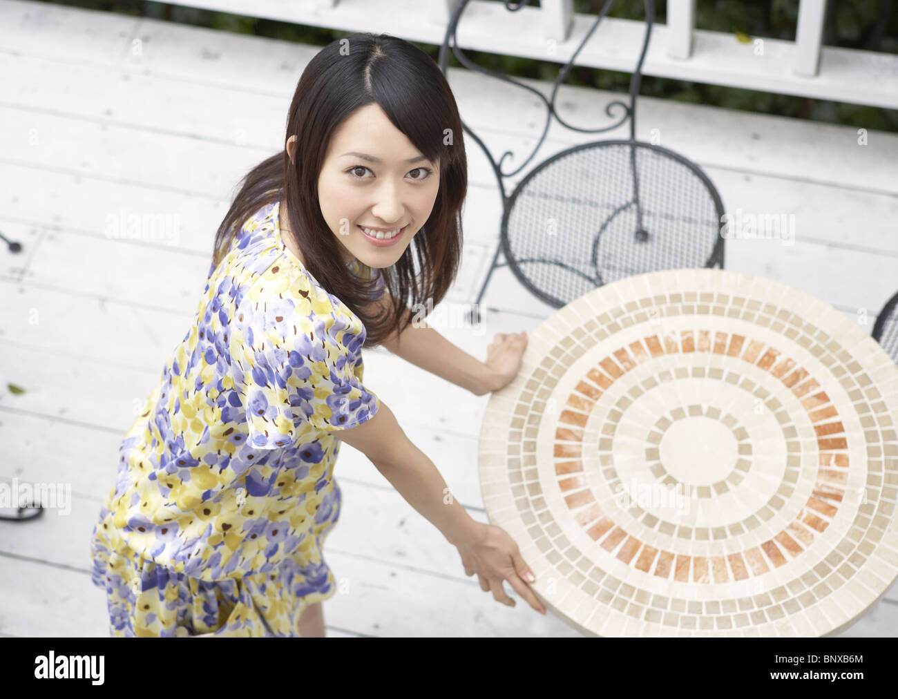 Young woman leaning on table Stock Photo - Alamy