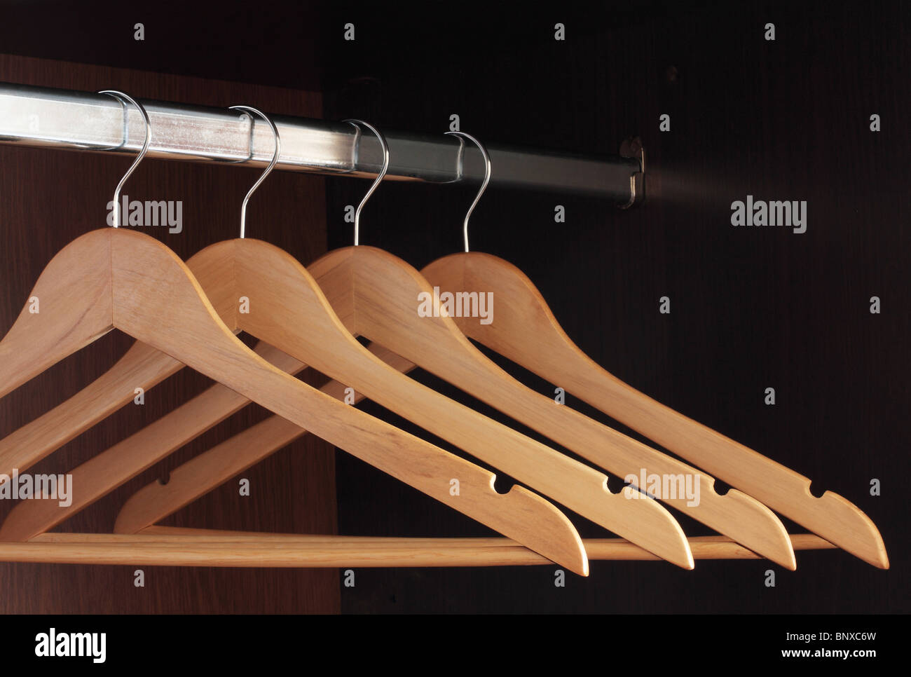 Wooden hangers hanging in an empty closet on the upper Stock Photo - Alamy