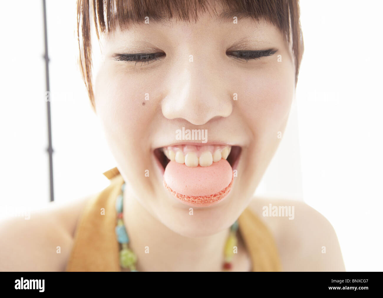 Young woman eating macaroon Stock Photo - Alamy