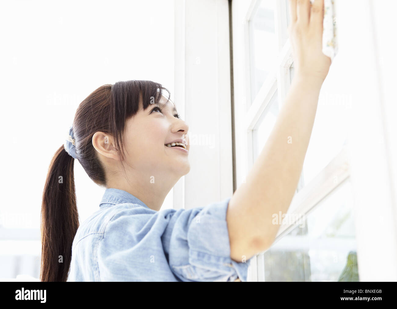 Young woman wiping the window Stock Photo - Alamy