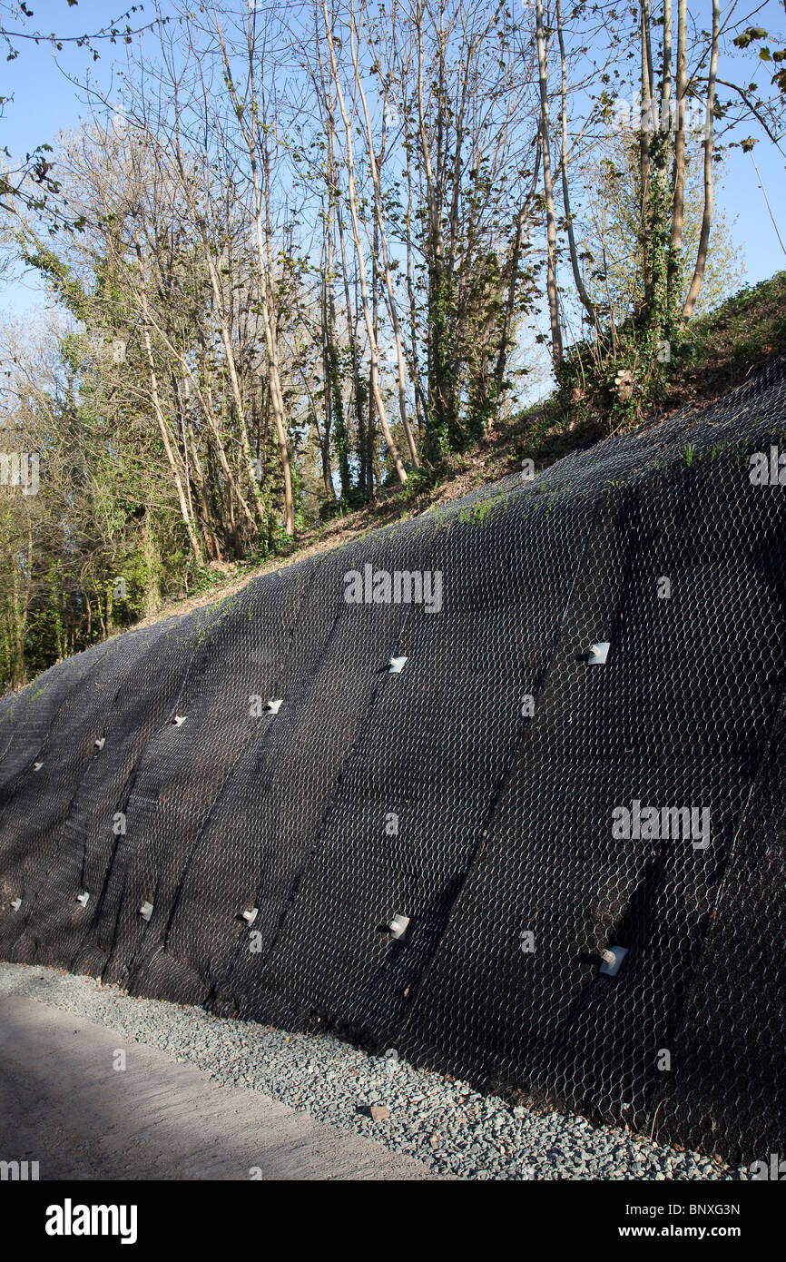 Unstable bank covered with retaining mesh and bolts to hold the bank in ...
