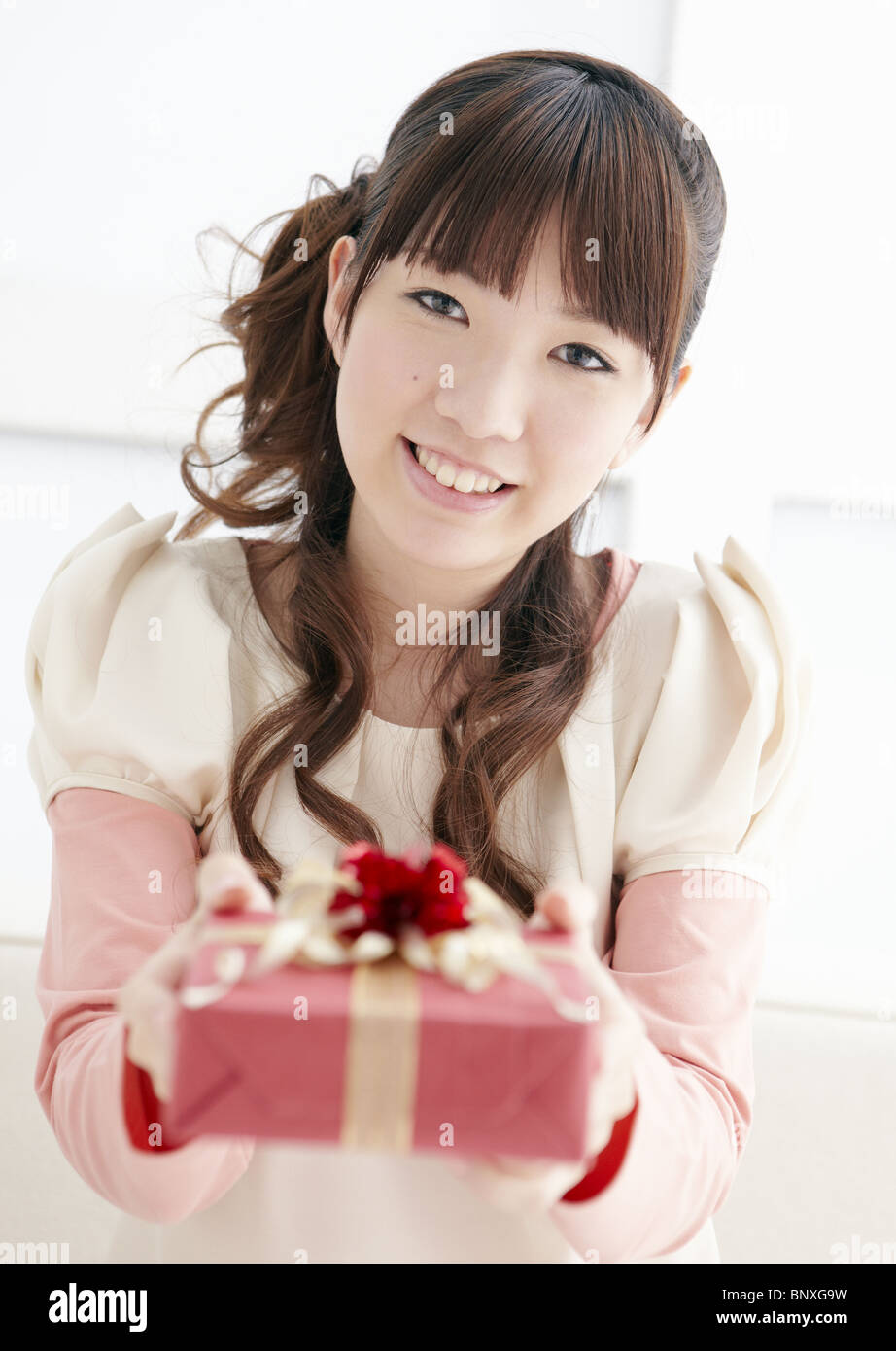 Young woman giving a gift Stock Photo - Alamy